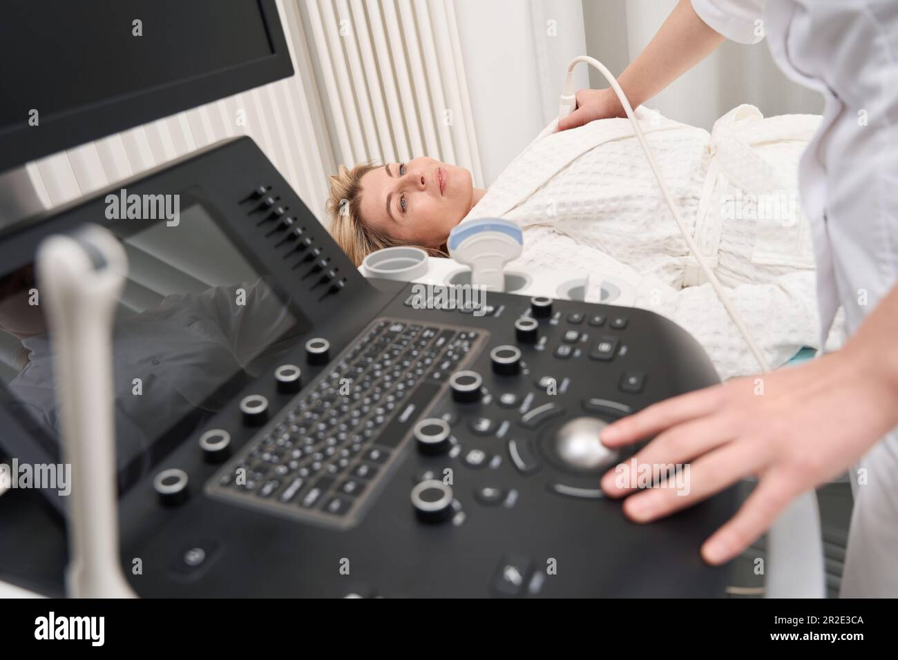 Ultrasound specialist makes an ultrasound of the heart to lady Stock ...