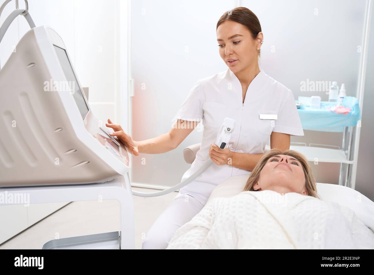 Qualified female specialist adjusts the apparatus for mas lifting Stock ...