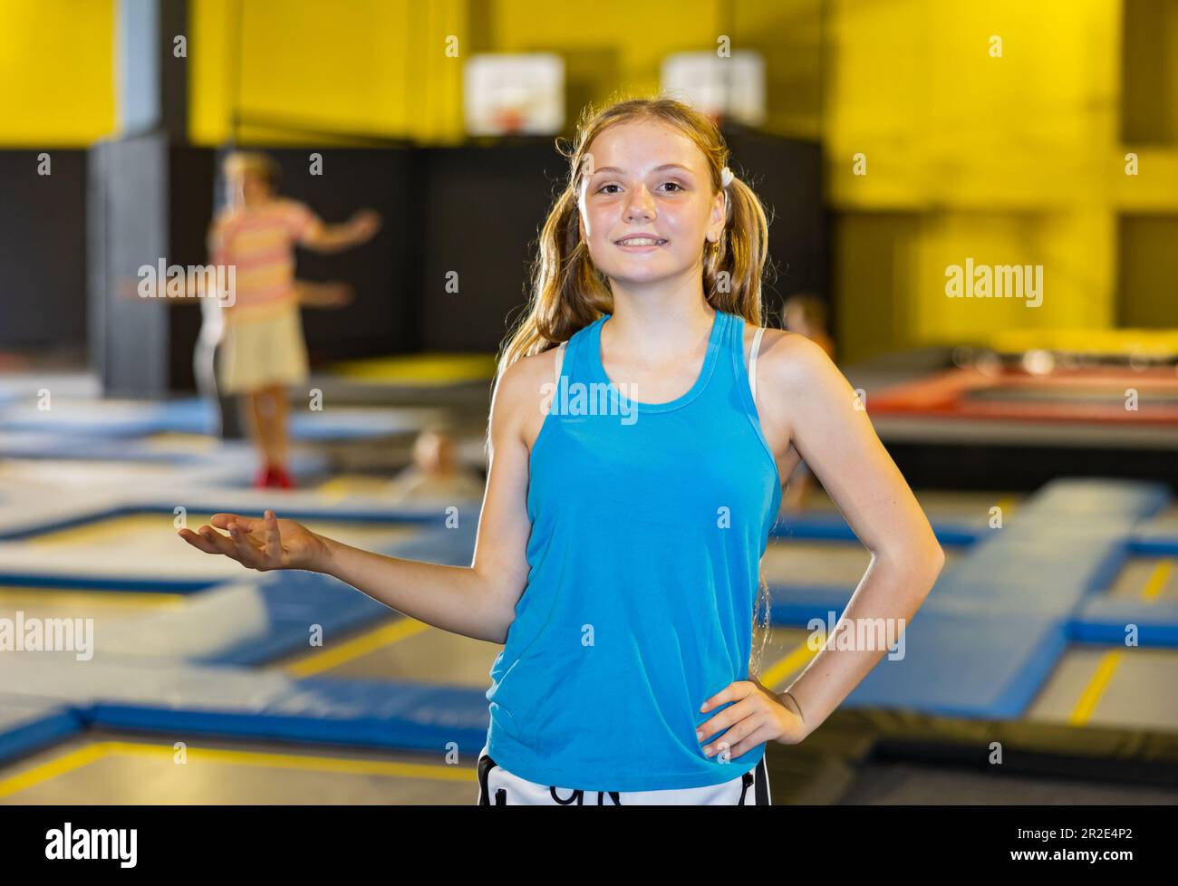 Happy teen girl in blue jersey posing on trampolines during active ...