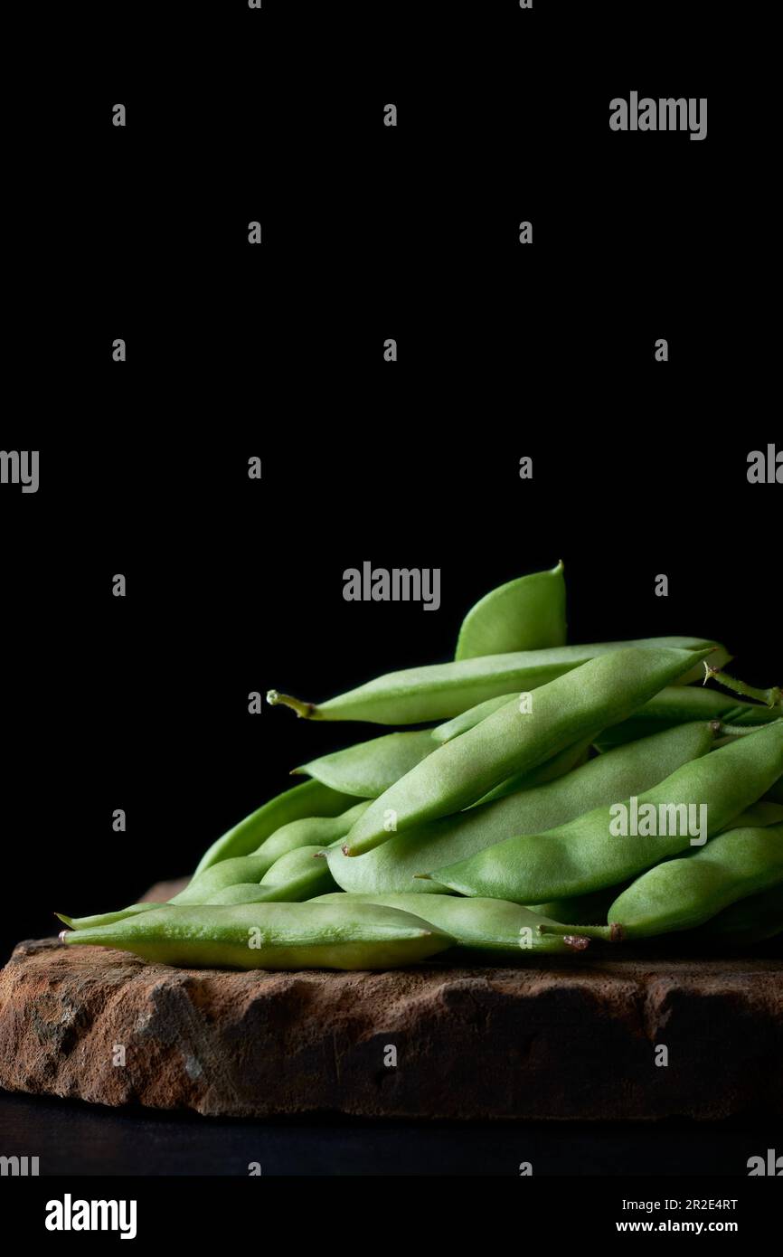 pile of pea pods on cutting board, type of legume that is widely ...