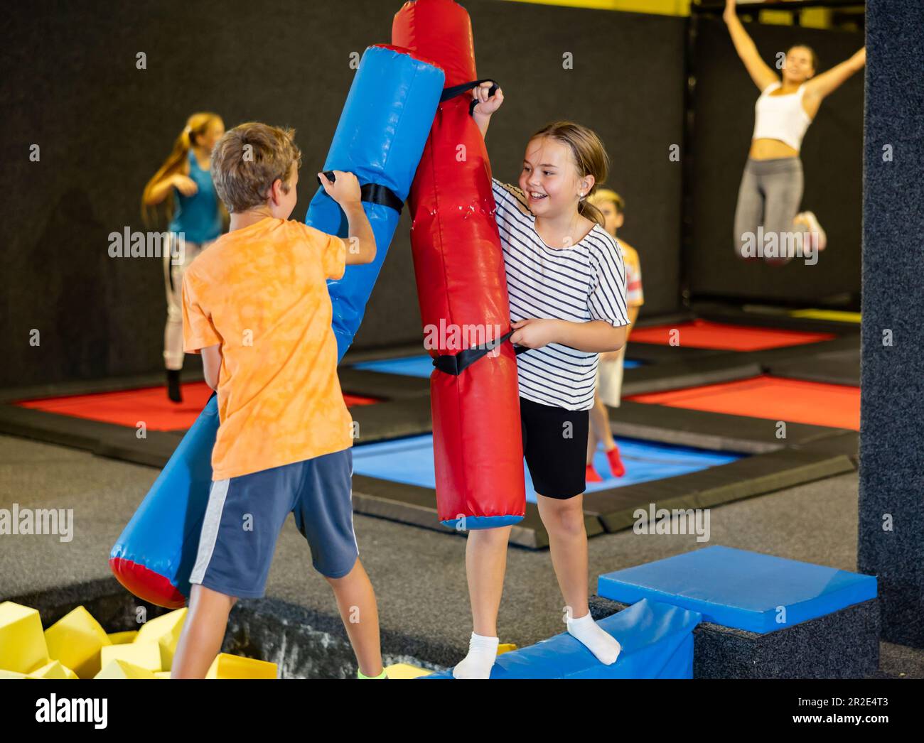 Cheerful school-age boy and girl friends having fun on inflatable ...