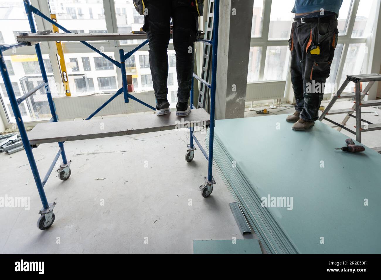 Workers fitting panel into frame of ceiling Stock Photo - Alamy