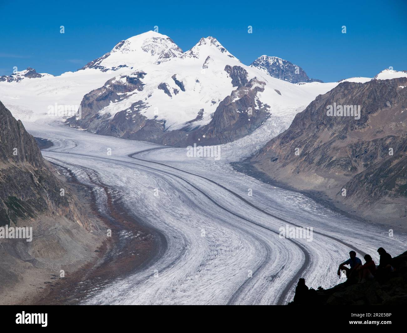 Walkers picnic on some rocks above the Aletsch glacier, Switzerland's ...
