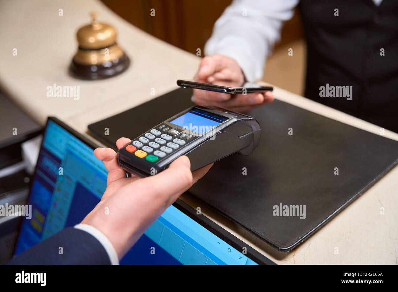 Administrator holding credit card reader, male customer making ...