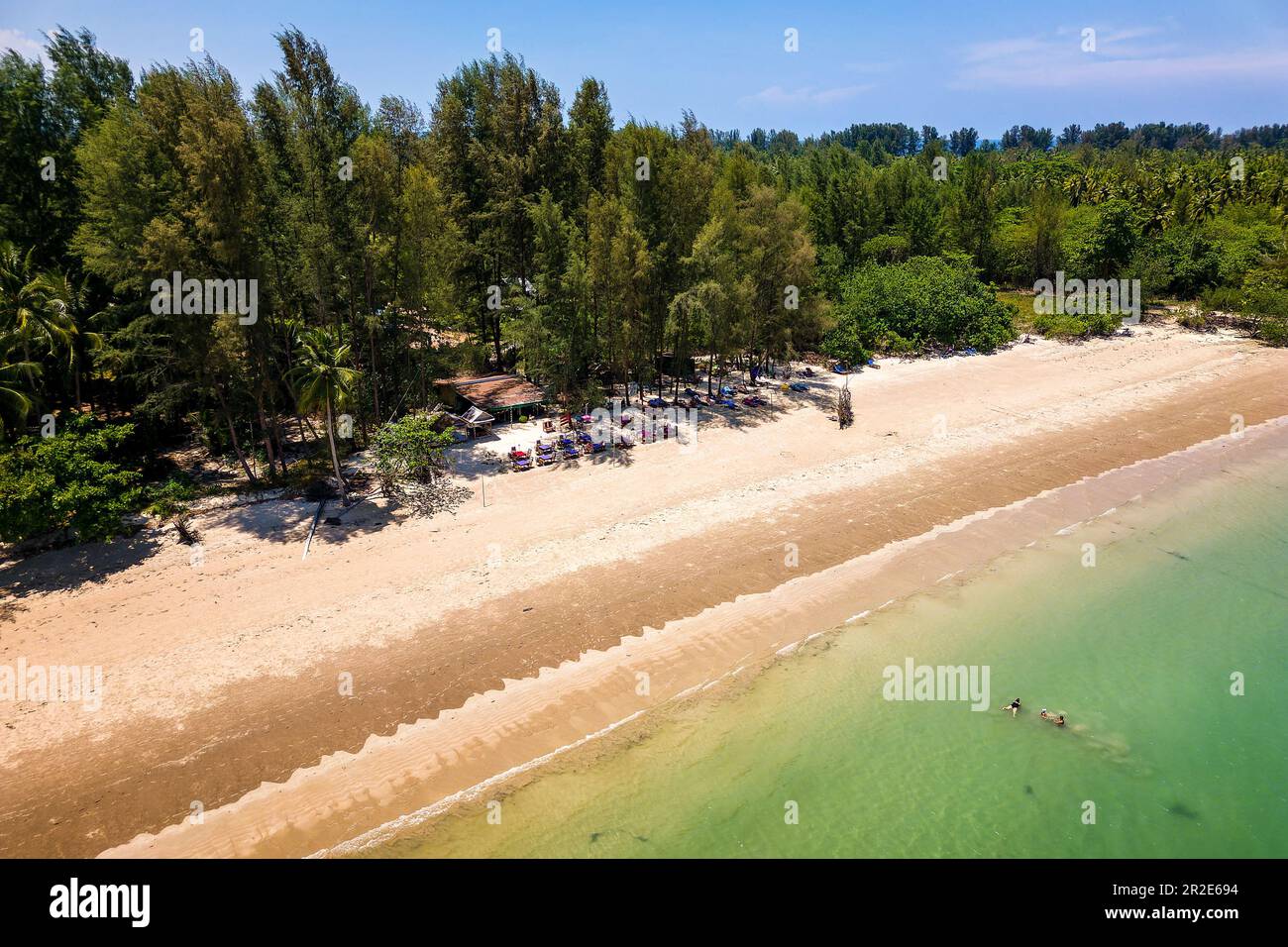 Aerial view of a small beach bar on a tropical sandy beachd fringed by ...
