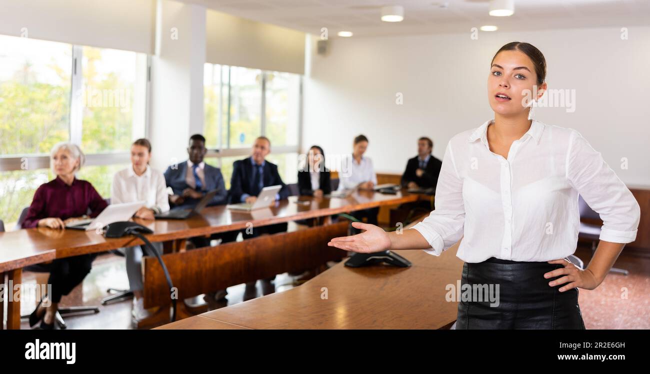 Female office employee standing at workplace in meeting room, making ...