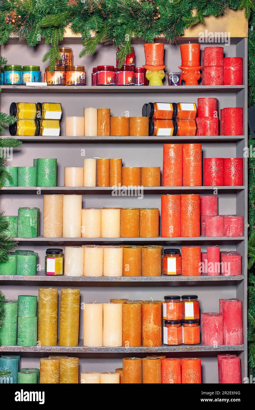 The cabinet shelves are filled with scented candles in various colors ...