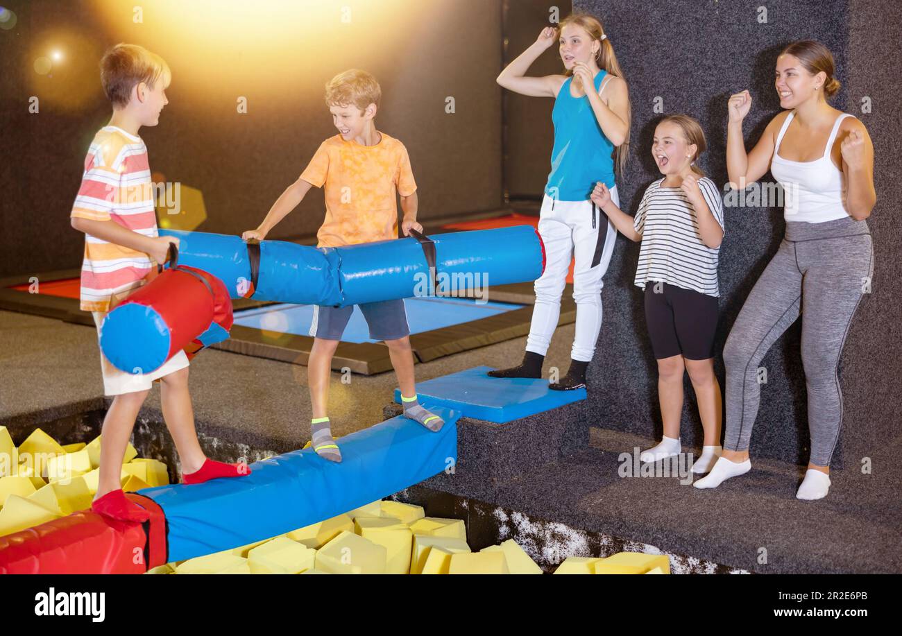 Tween boy having fun on battle beam with friend Stock Photo - Alamy