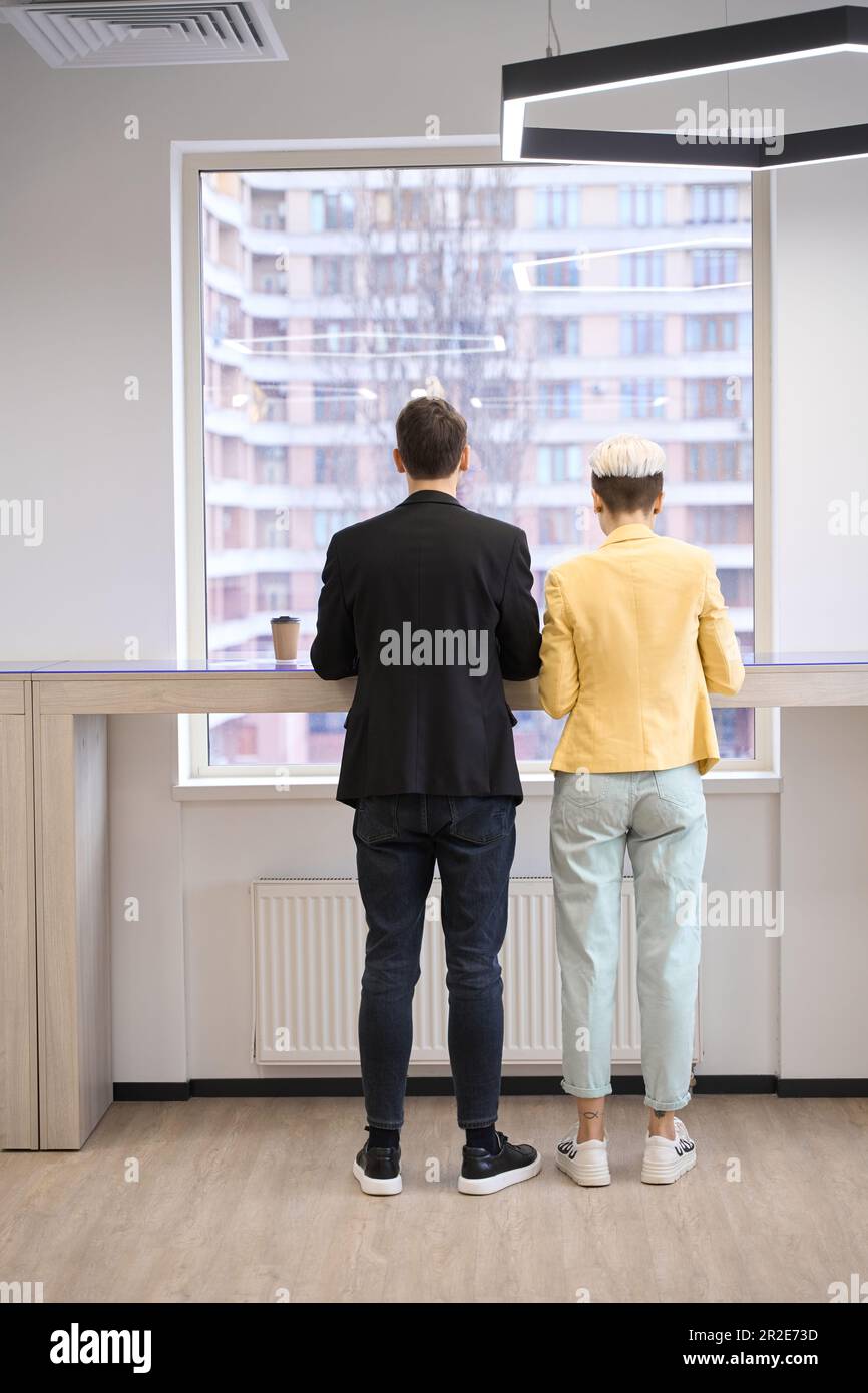 Back-view man and woman working near window Stock Photo - Alamy