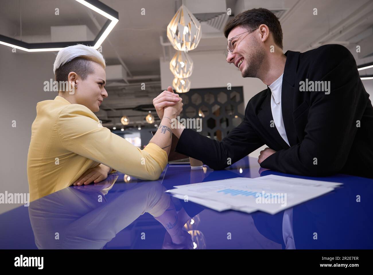 Colleagues arm-wrestling for project supervision in the office Stock ...