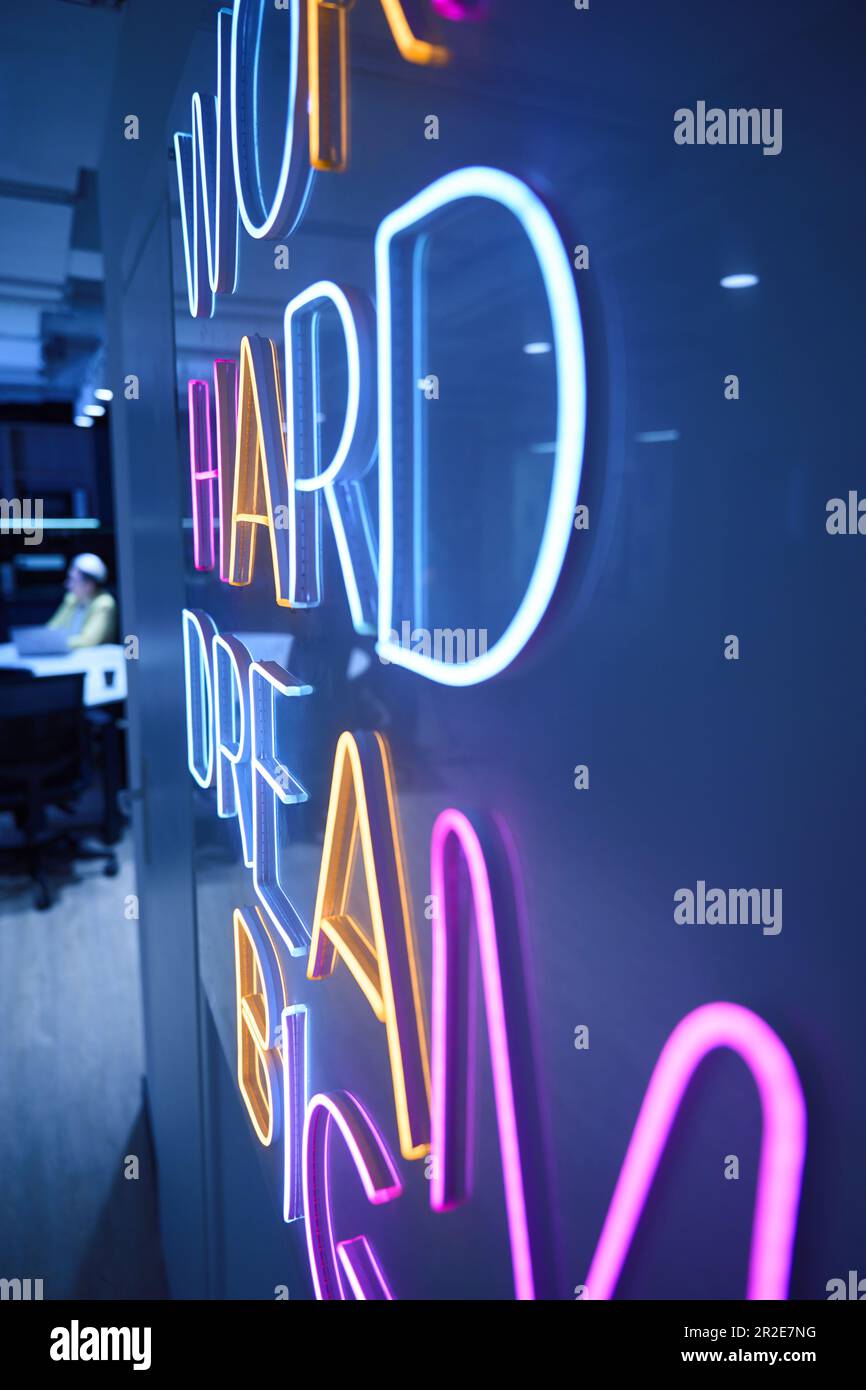 Neon motivational sign on the wall in the office Stock Photo - Alamy