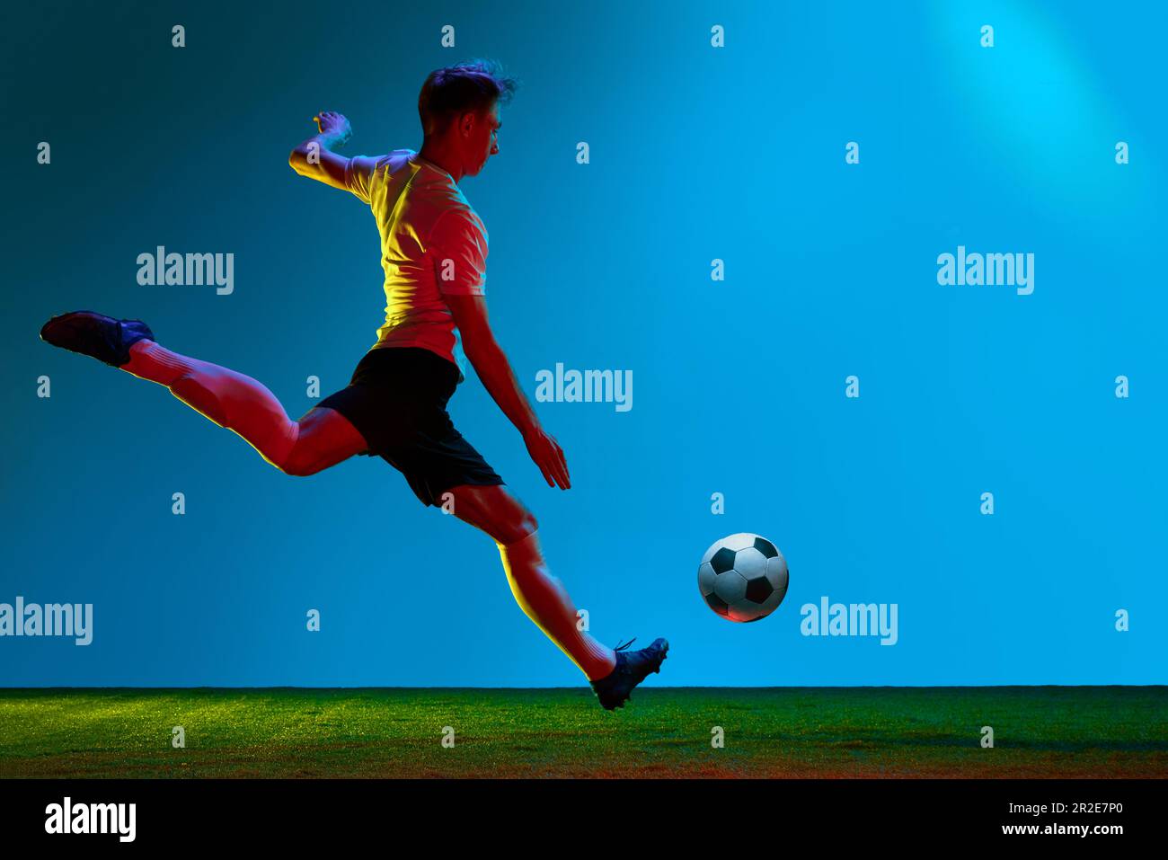 Professional man, football player in sports team uniform running over ...