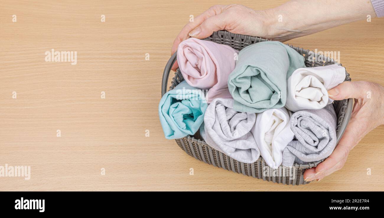 Women's hands fold clean clothes. Vertical storage of clothing in the ...
