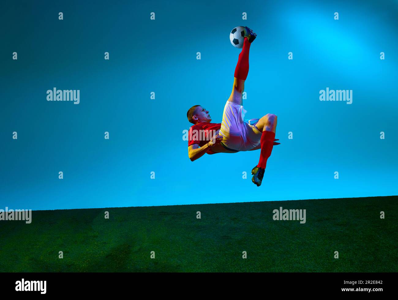 Professional man, football player in sports team uniform falling down ...