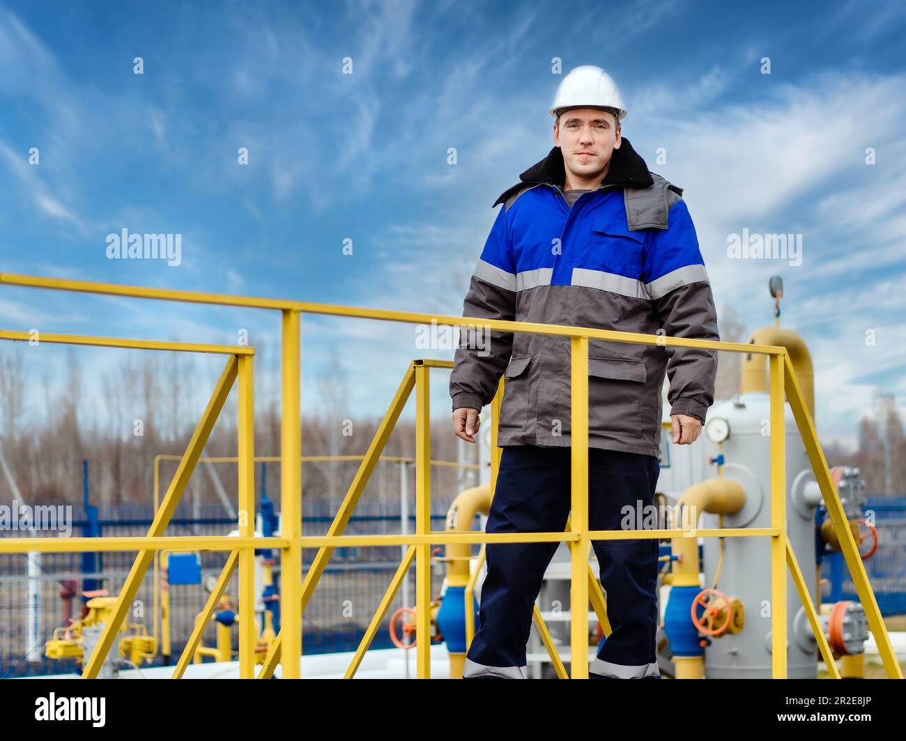 Portrait of worker in white helmet and winter pea jacket at industrial ...
