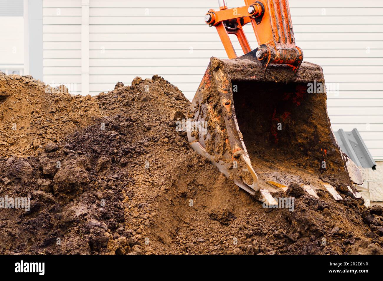 Dirty excavator bucket and pile of clay with earth close-up. Digging ...