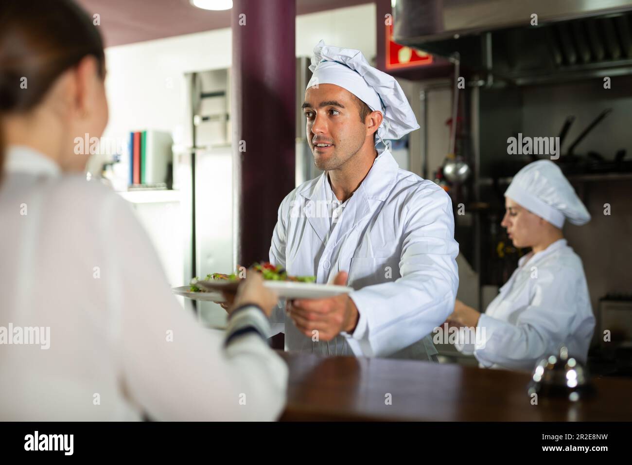 Service process in cafe - chef serves ready meals to visitors of modern ...