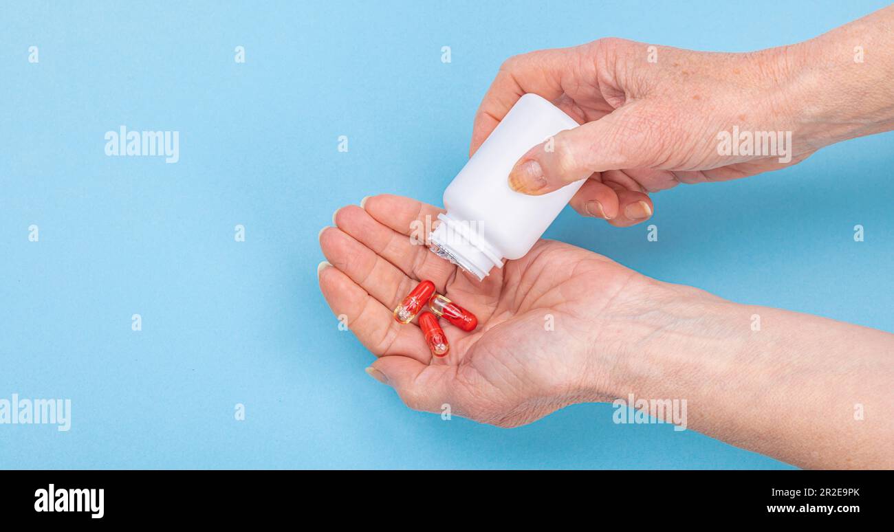 A woman takes medicine. Female hands hold capsules or pills. Treatment ...