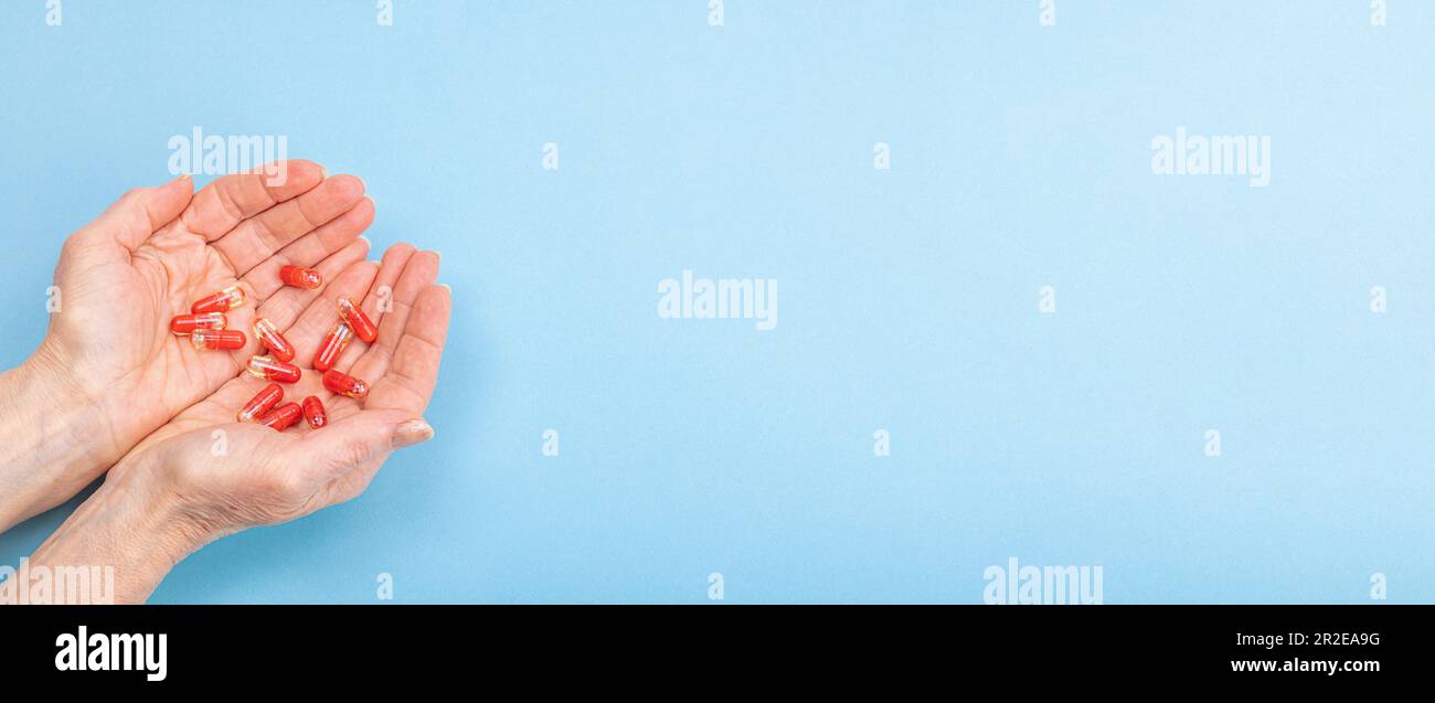 A woman takes medicine. Female hands hold capsules or pills. Treatment ...