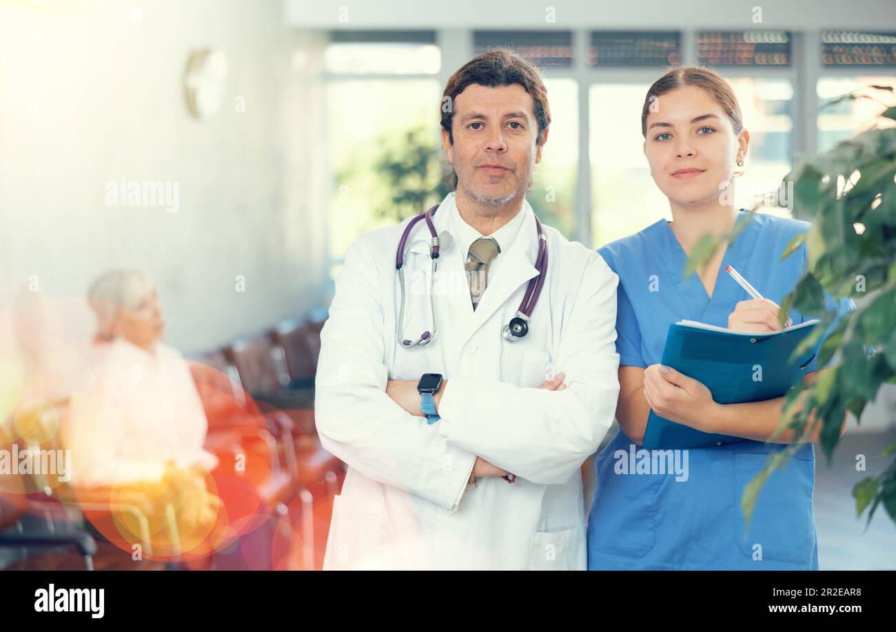 smiling man and young woman doctor stand in hall of medical center ...