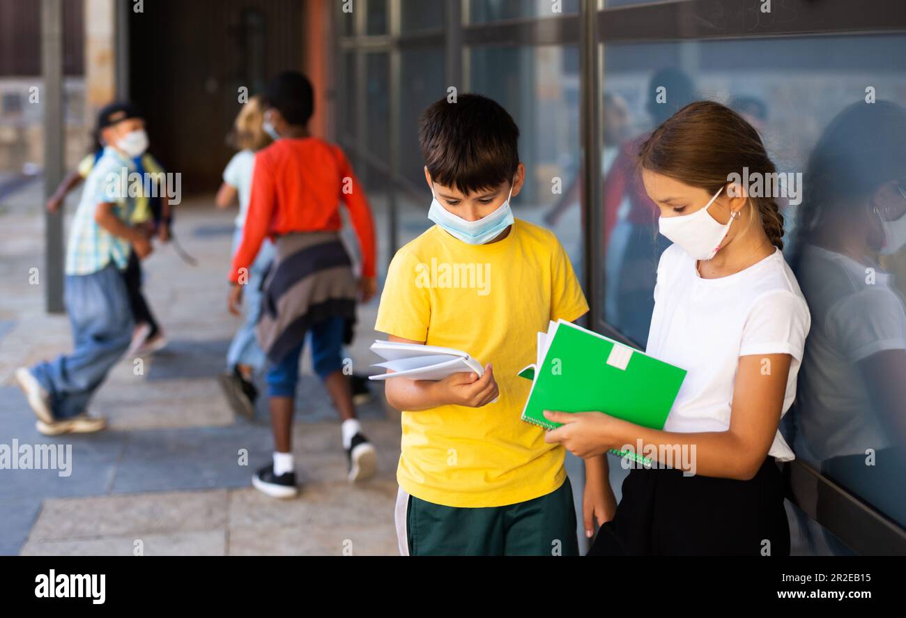 School tweens in medical masks in schoolyard during break Stock Photo ...