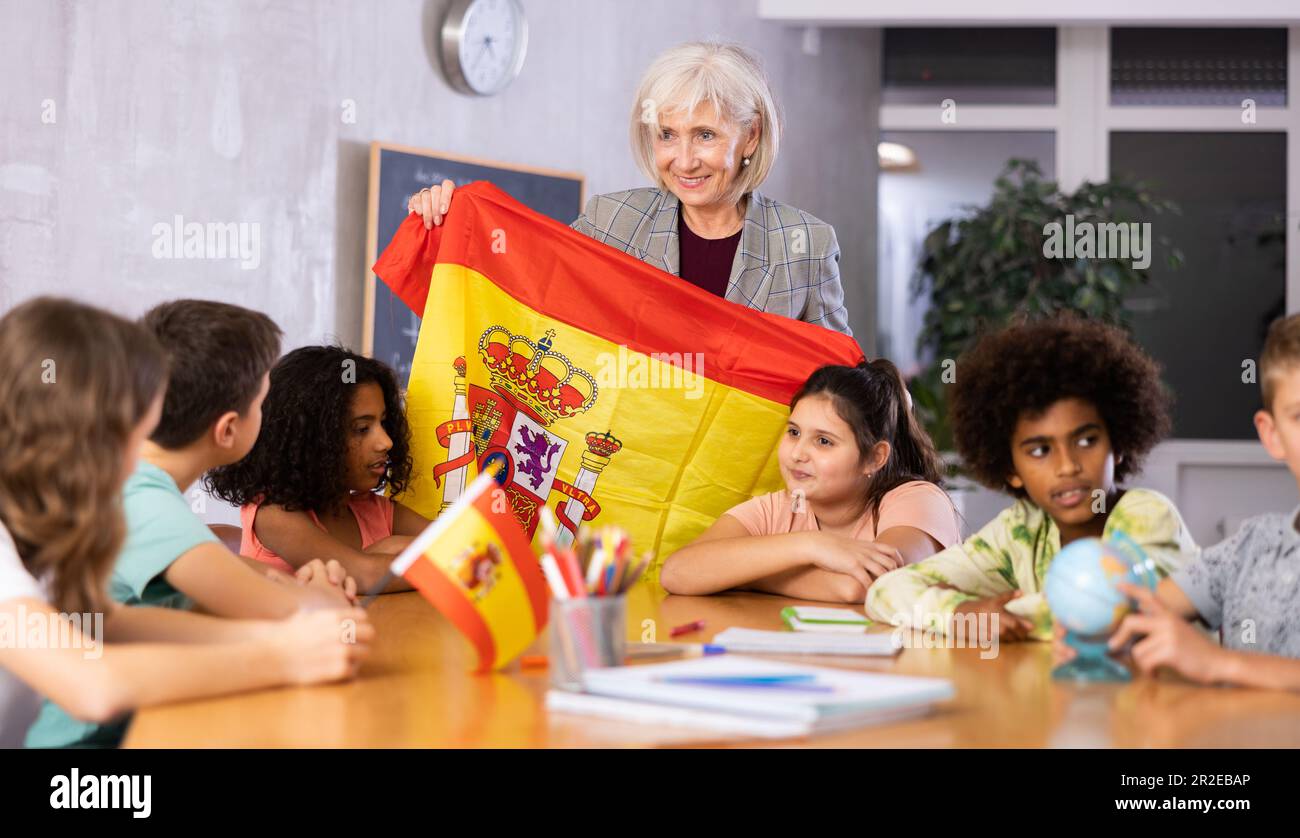 Female teacher showing spanish flag to kids in geography class Stock ...