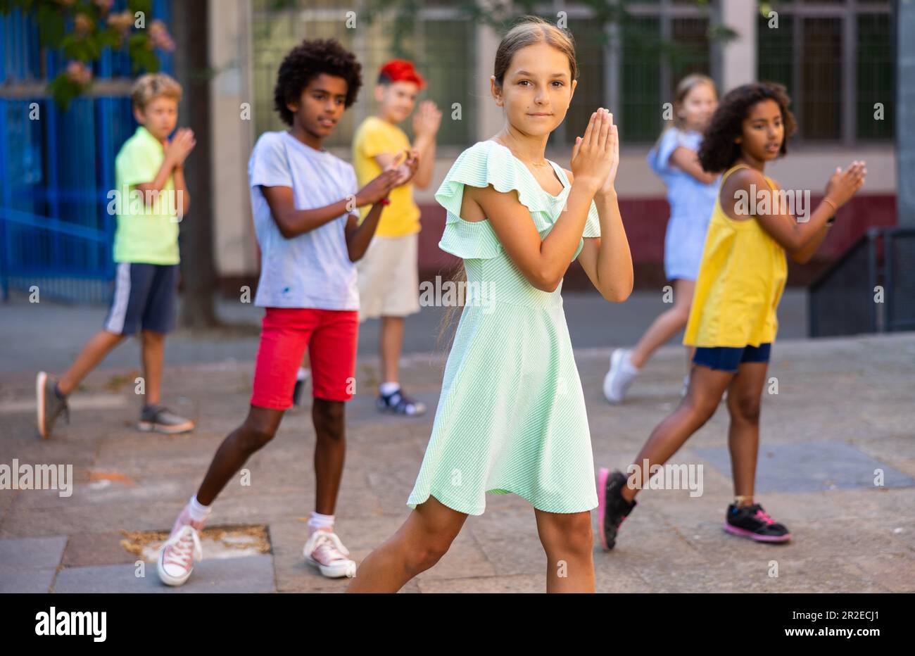 Smiling preteen girl dancing with friends on summer city street Stock ...