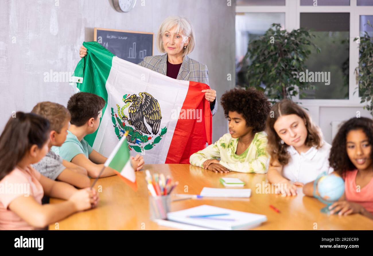 Female teacher showing mexican flag to kids in geography class Stock ...