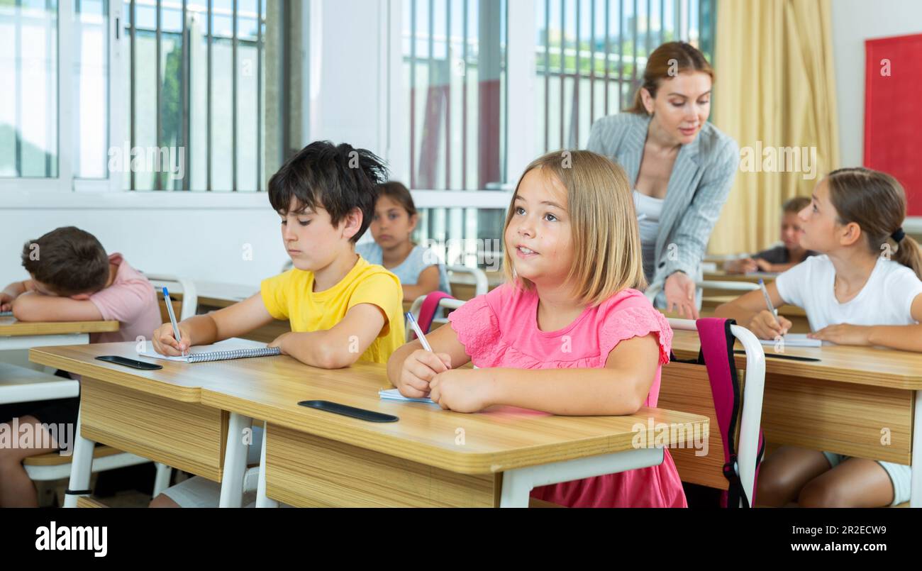 Group of school kids and teacher during lesson in classroom Stock Photo ...