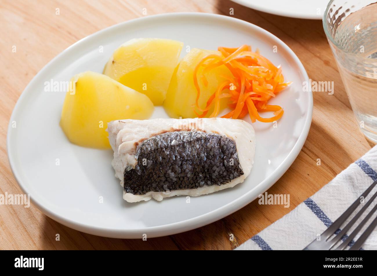 Cod prepared on steam with with carrots and potatoes, served at plate ...