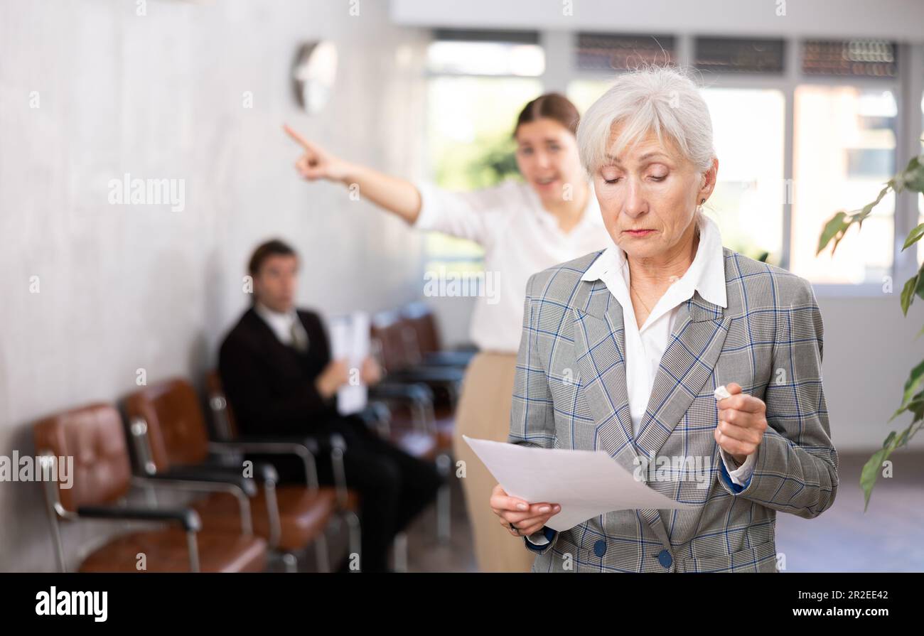 Upset aged female office worker scolded by angry woman boss Stock Photo ...