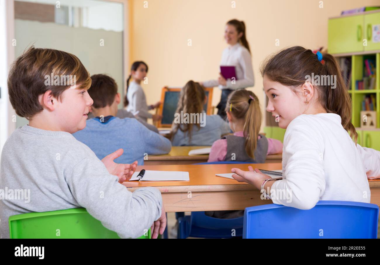Pupils chattering at lesson Stock Photo - Alamy