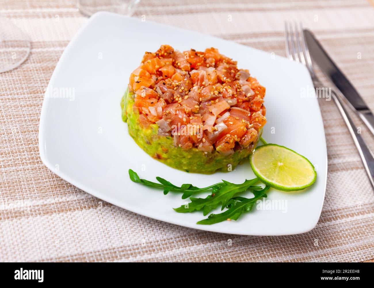Salmon tartare with guacamole and slice of lime Stock Photo - Alamy