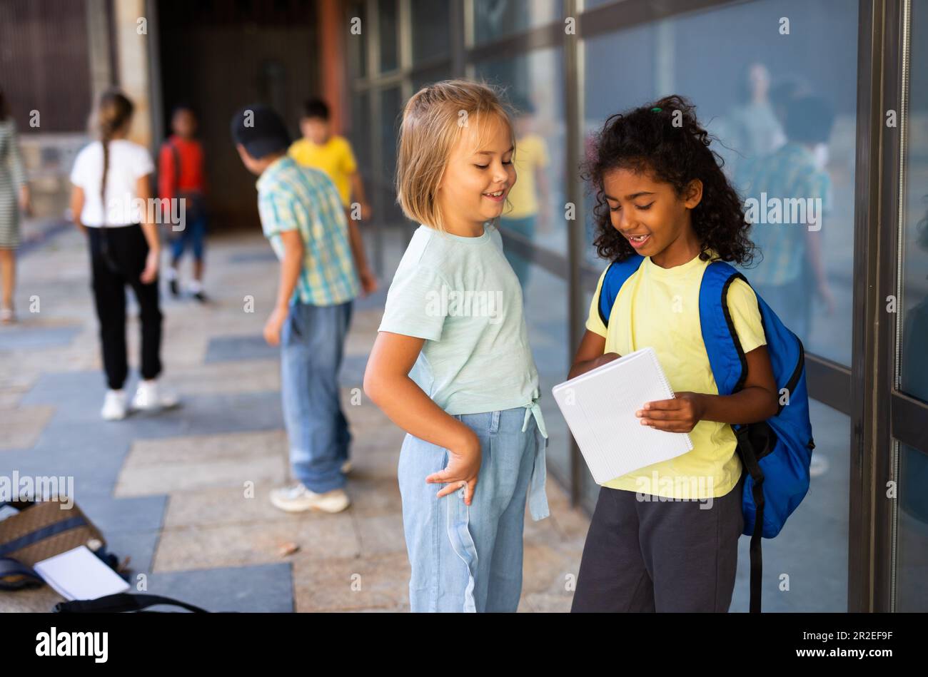 Smiling tween girls friendly discussing in schoolyard Stock Photo - Alamy