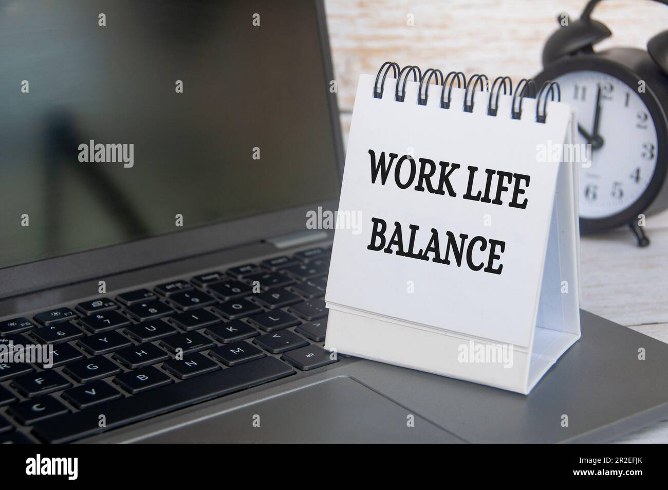 Work life balance text on table notepad with laptop background. Working ...