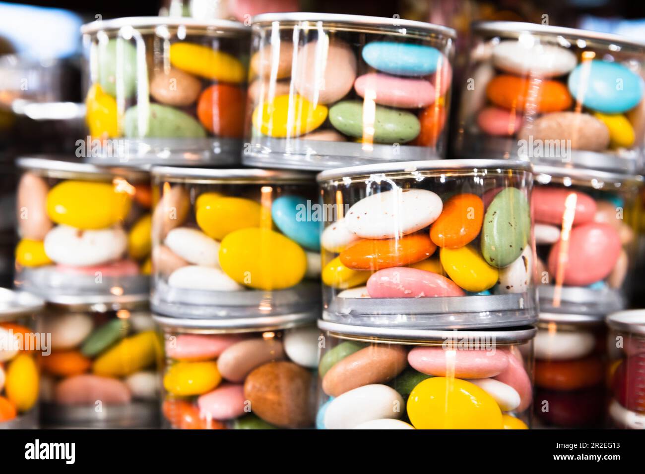 Colorful dragee Candies are packed in transparent plastic jars. Candy ...