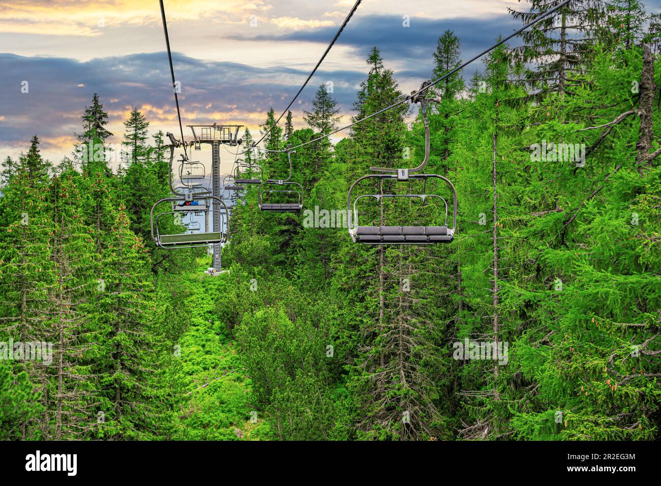 Tourist double lift above the forest on the mountain slope Stock Photo ...