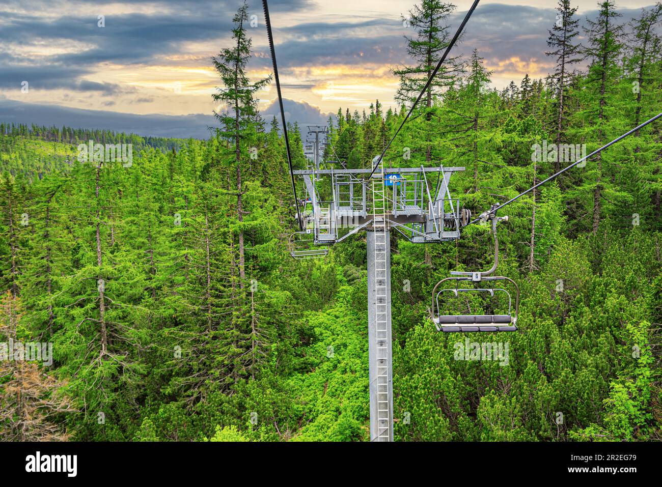 Tourist double lift above the forest on the mountain slope Stock Photo ...