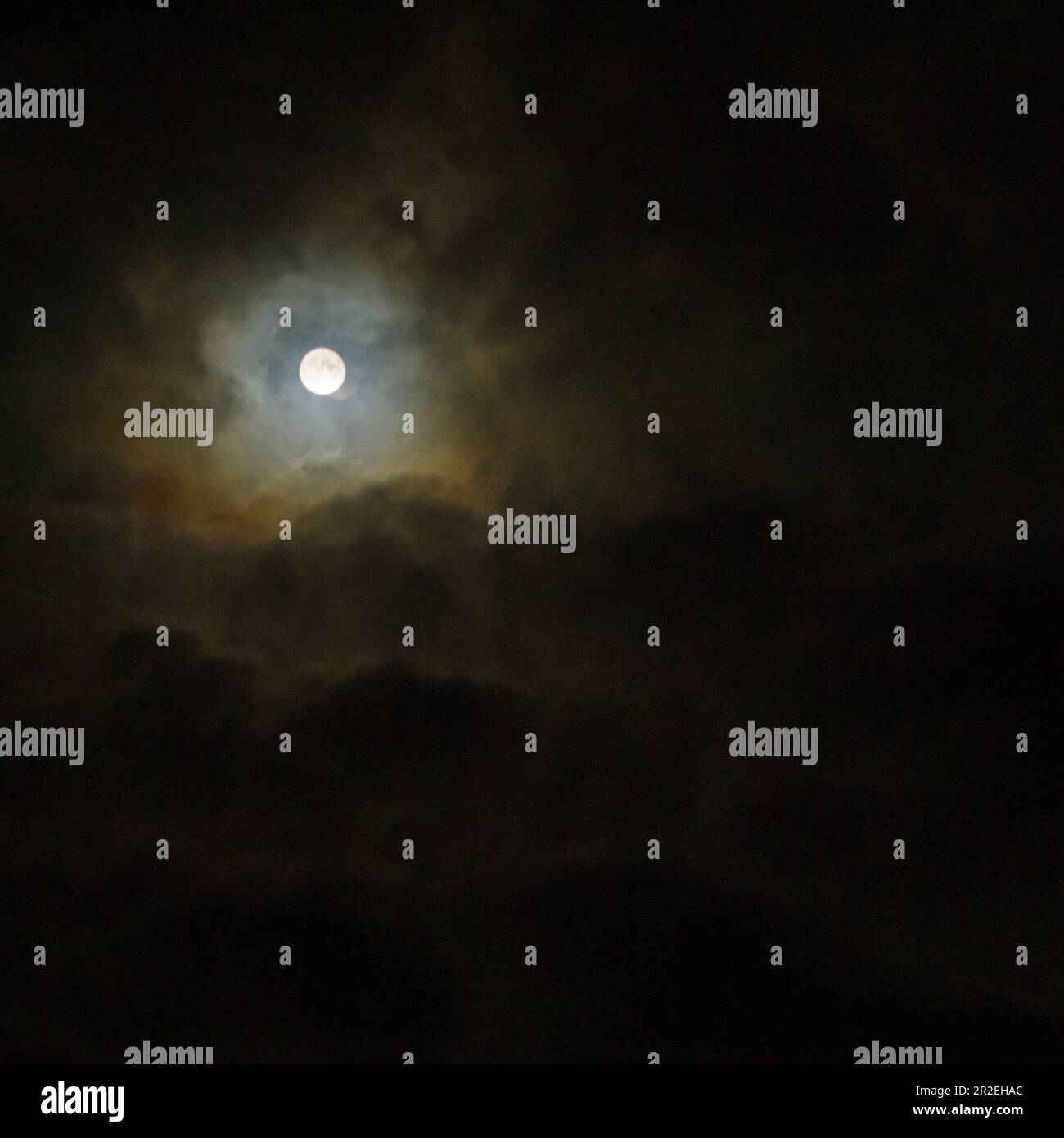 The full moon shines among the clouds in the night sky. Full moon in the sky Stock Photo - Alamy