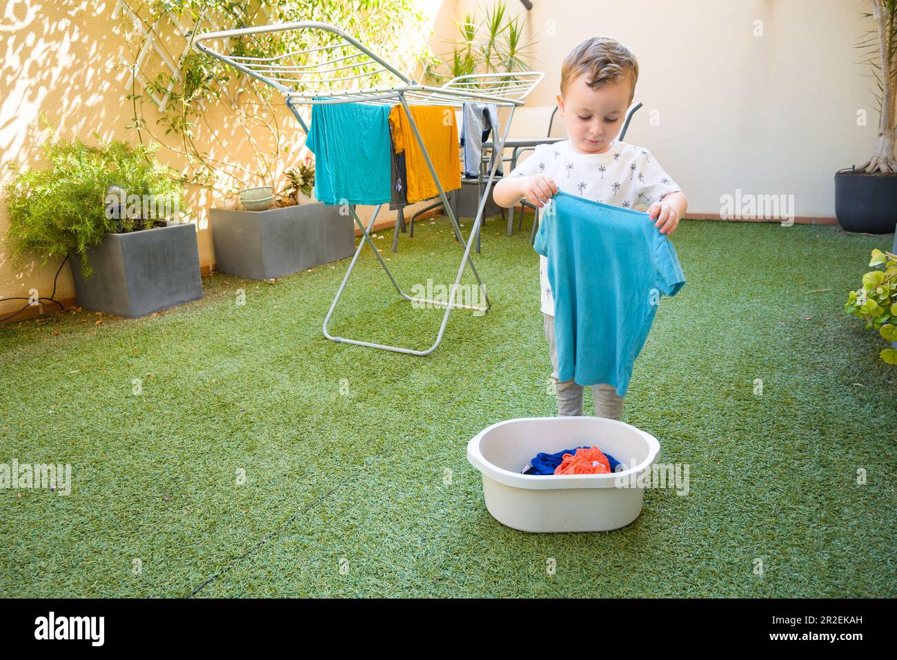 Funny boy with cloth and clothesline. Dry baby clothes on a rope Stock ...