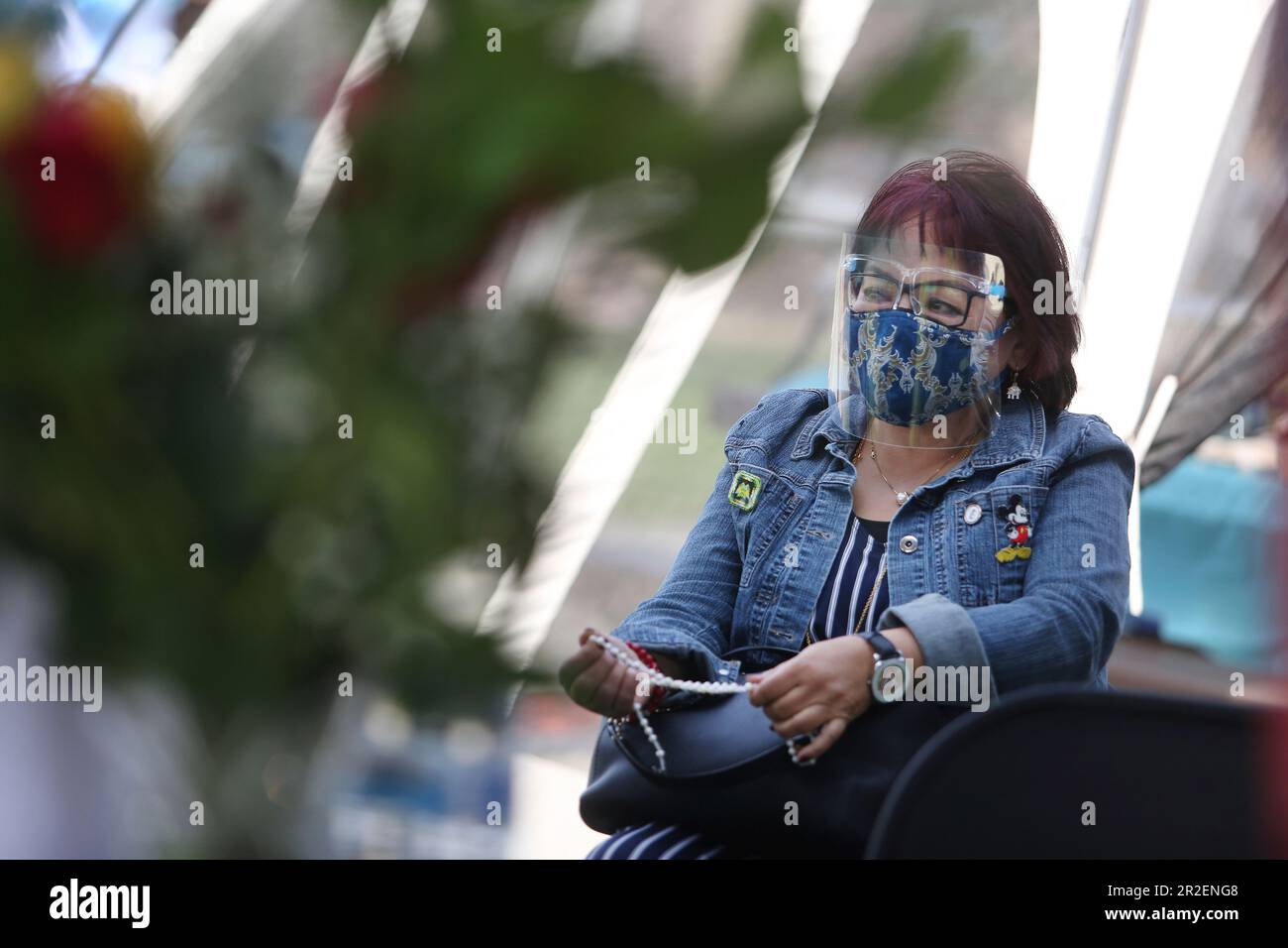 Jeannie Atienza holds her rosary and prays with other guests as she ...