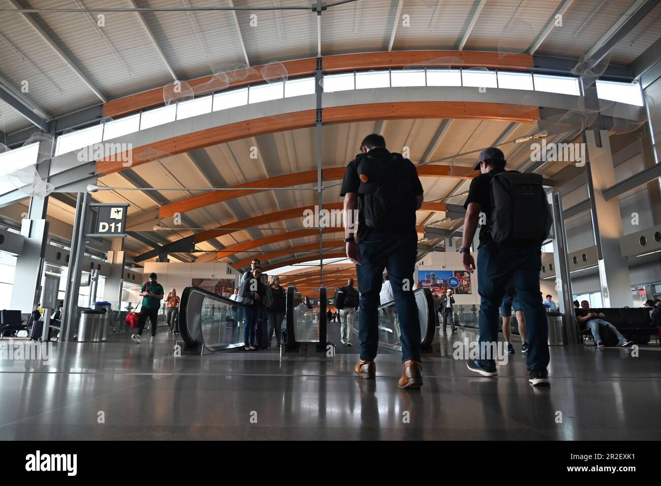 Travelers walk past the camera between gates in Terminal Two of Raleigh ...