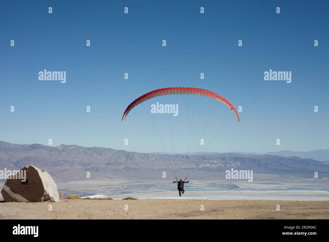 Paraglider takes off in a blue sky in front of the White Mountains ...