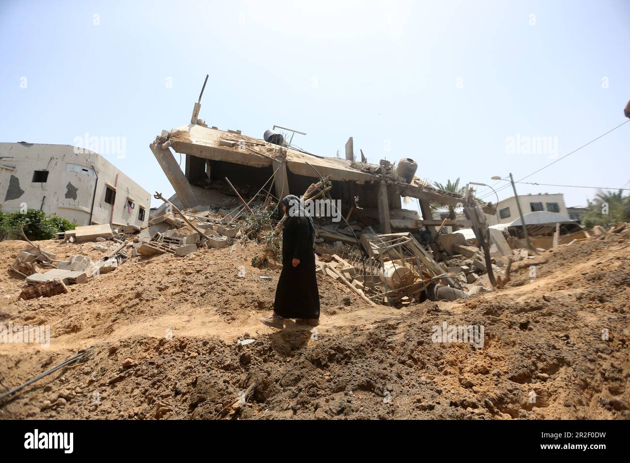 A woman is seen in front of a destroyed building belonging to the Al ...