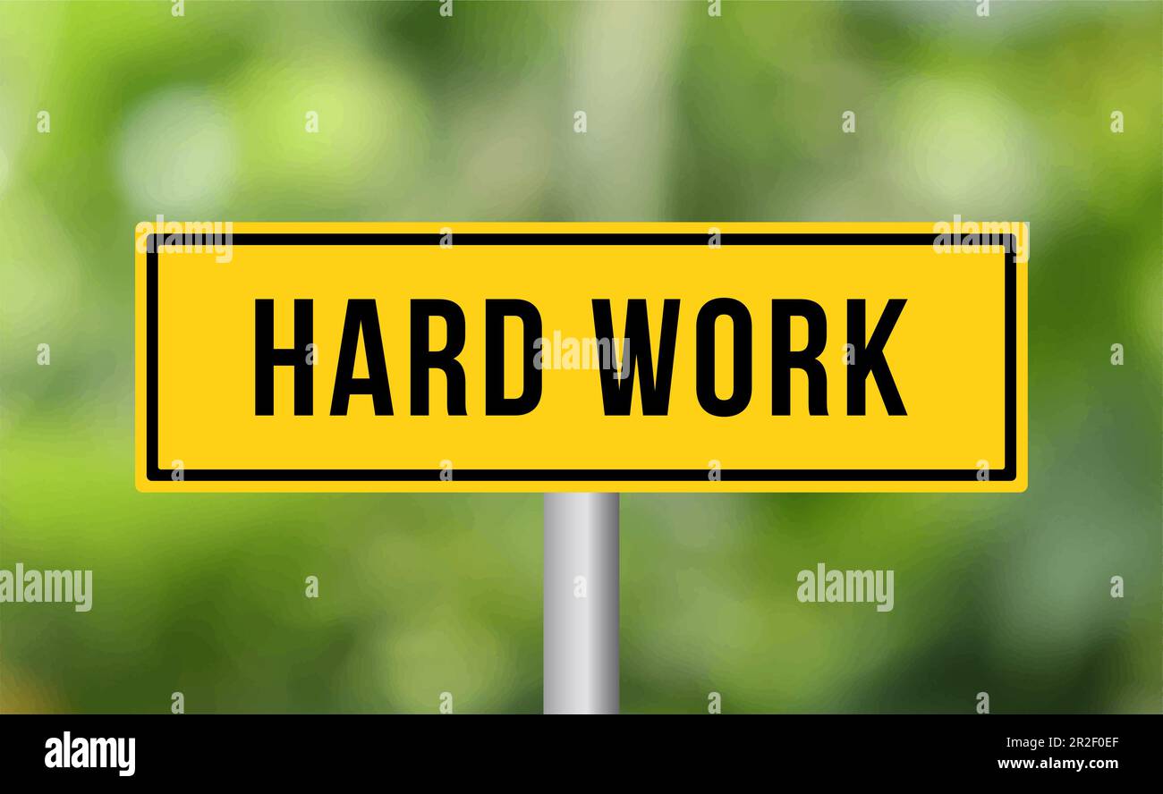 Hard work road sign on blur background Stock Photo - Alamy