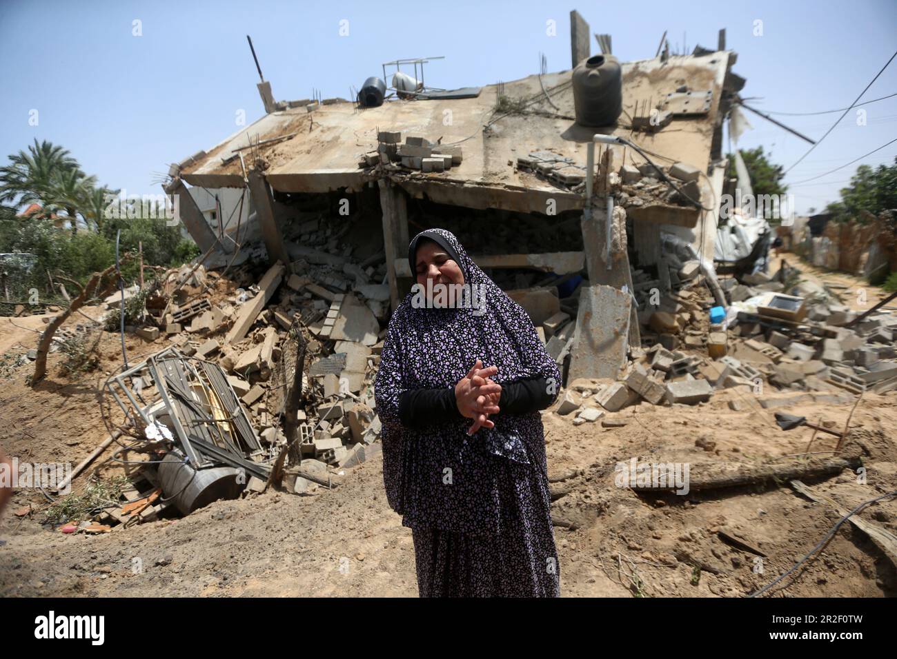 A woman is seen in front of a destroyed building belonging to the Al ...
