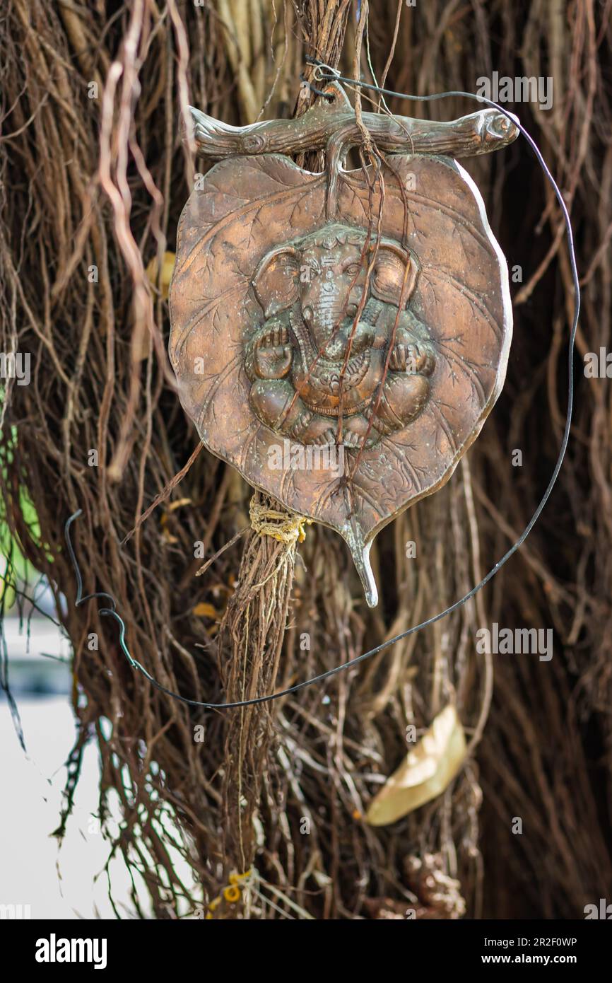 Hindu god ganesha idol hanging with tree branch at day Stock Photo - Alamy