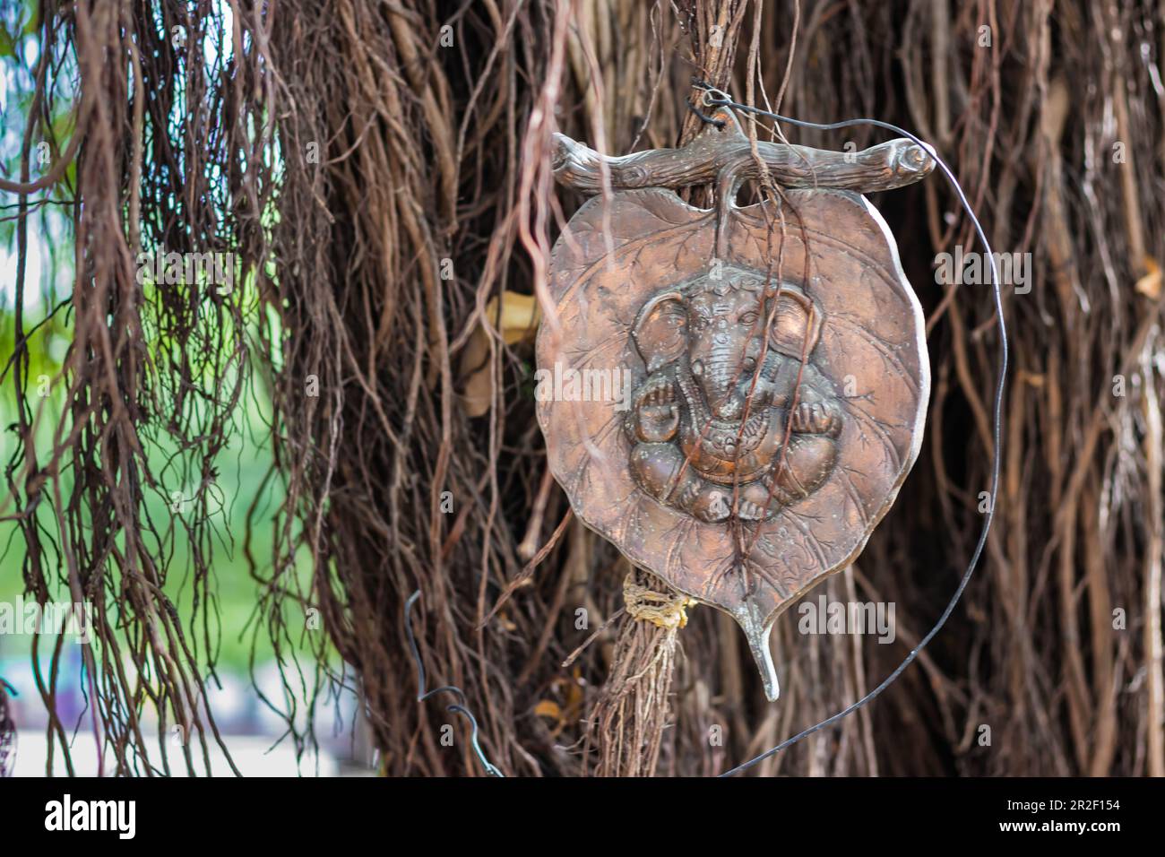 Hindu god ganesha idol hanging with tree branch at day Stock Photo - Alamy