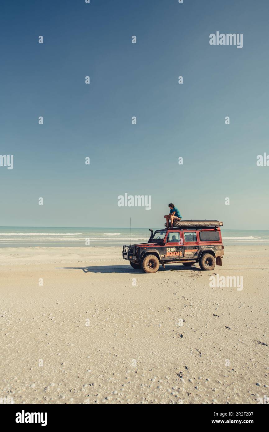Man sitting on off-road vehicle at 80 Mile Beach in Western Australia ...