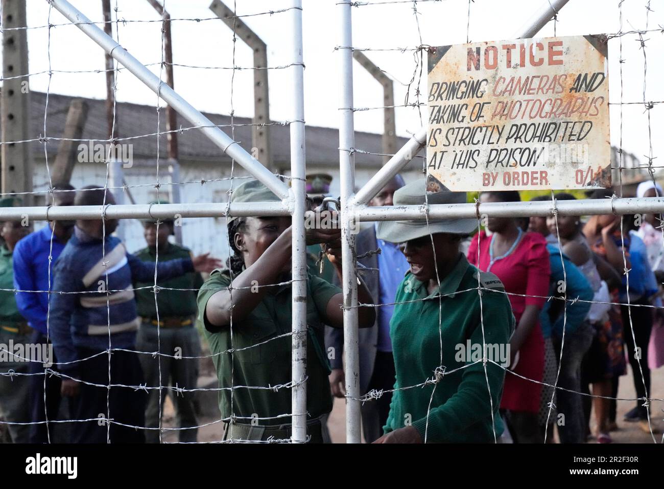 A prison officer opens the gate to release freed female prisoners from ...